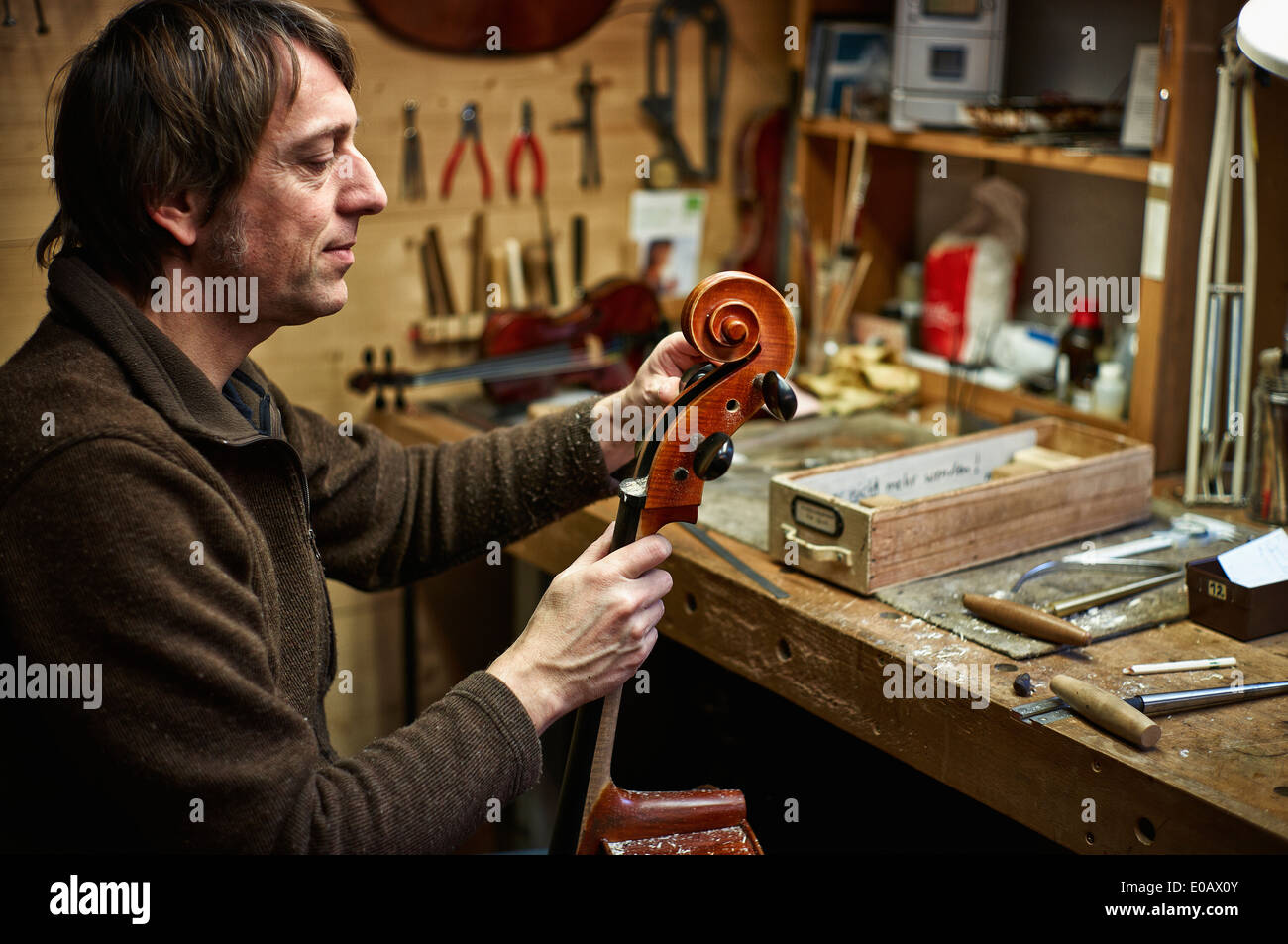 Violin maker in his workshop adjusting a cello mechanism Stock Photo ...
