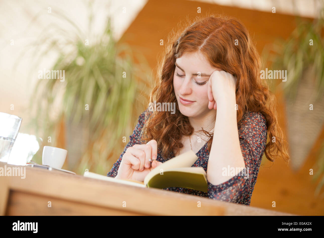 Young woman with note-book writing in cafe Stock Photo - Alamy