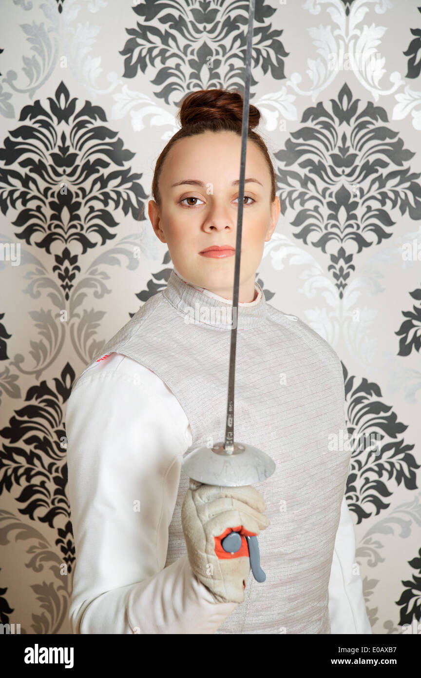 Portrait of young female fencer with floret in front of checkered ...