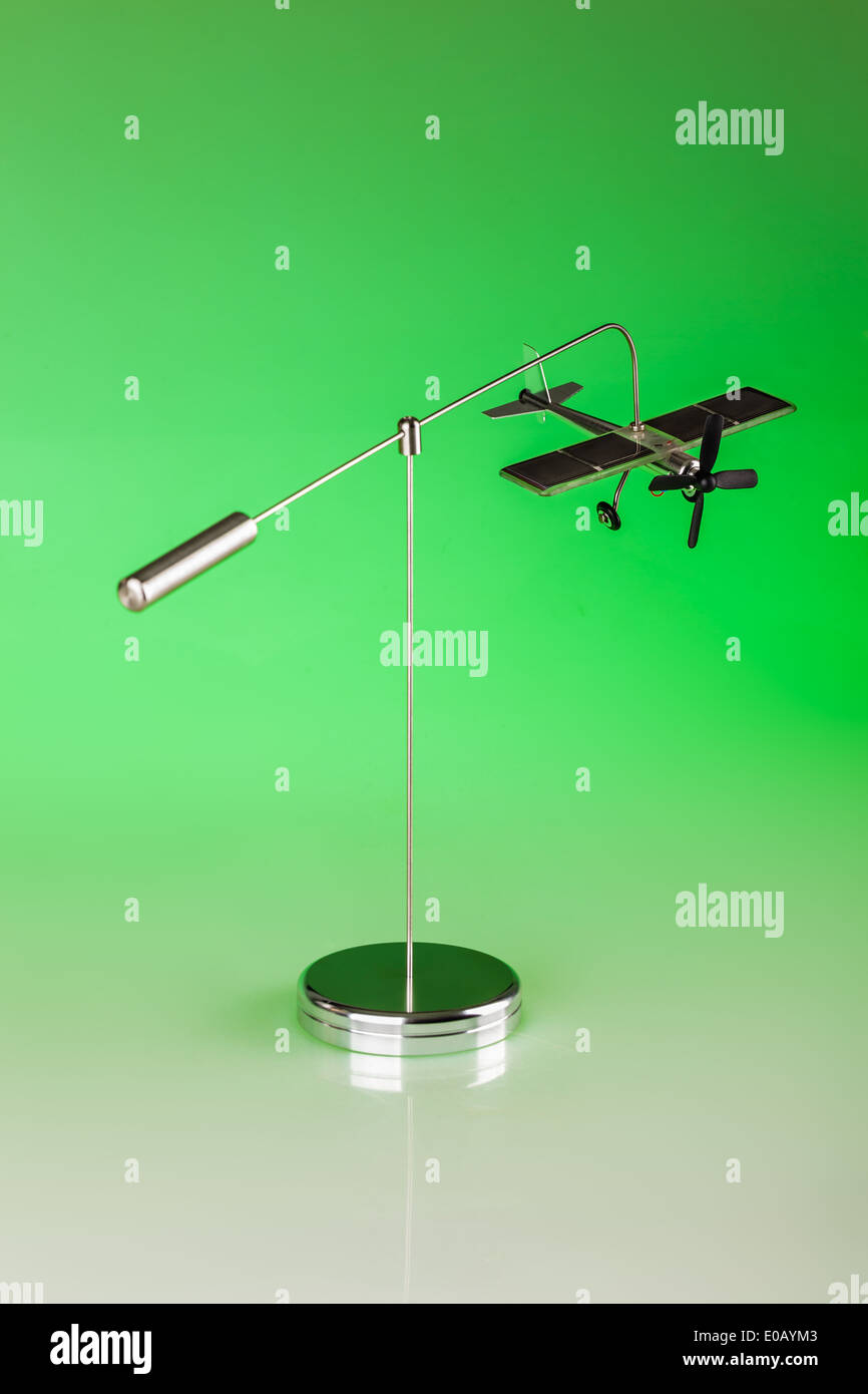 a metal toy plane with solar panels over a colored background Stock ...