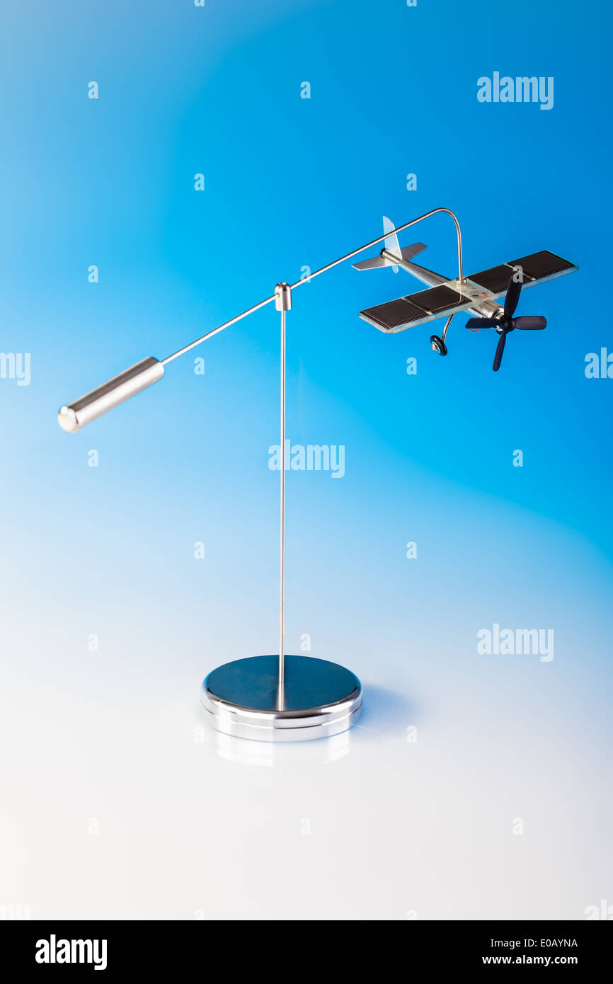 a metal toy plane with solar panels over a colored background Stock ...