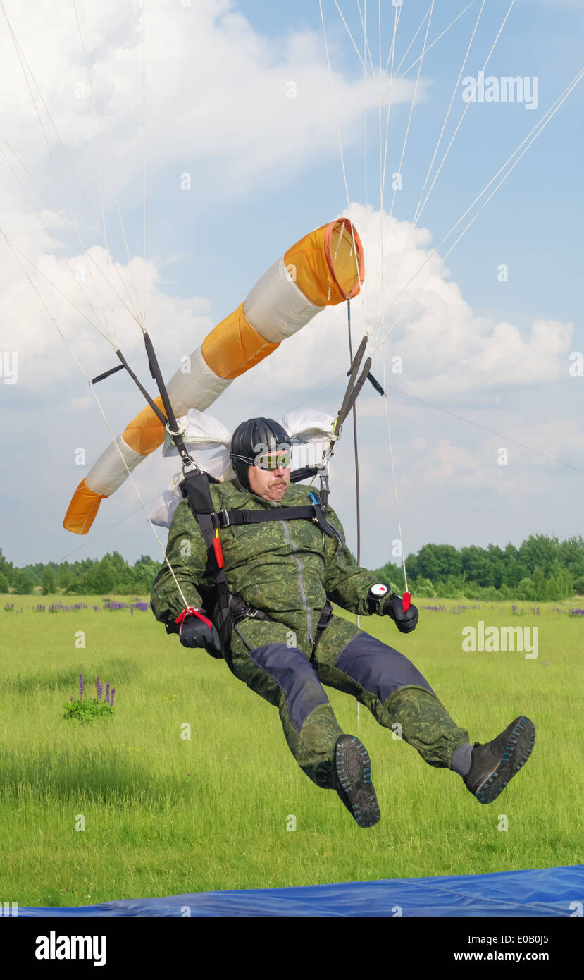 One day with parachutist in airfield. The skydiver lands under the ...