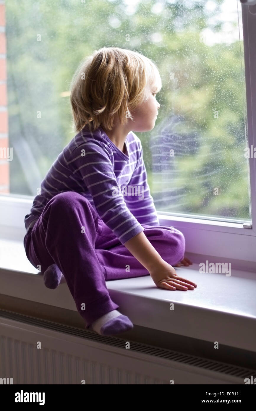 Little girl looking out of window Stock Photo - Alamy