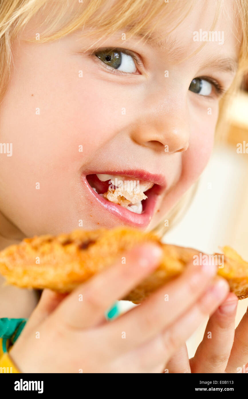Portrait of little girl eating Stock Photo - Alamy
