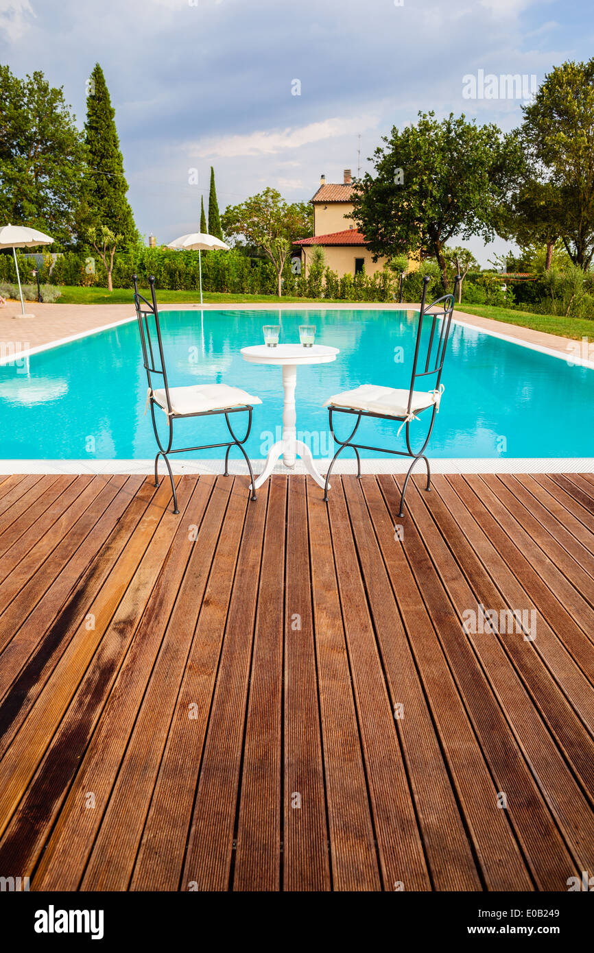 a beautiful and luxurious tuscany swimming pool with parasols and ...