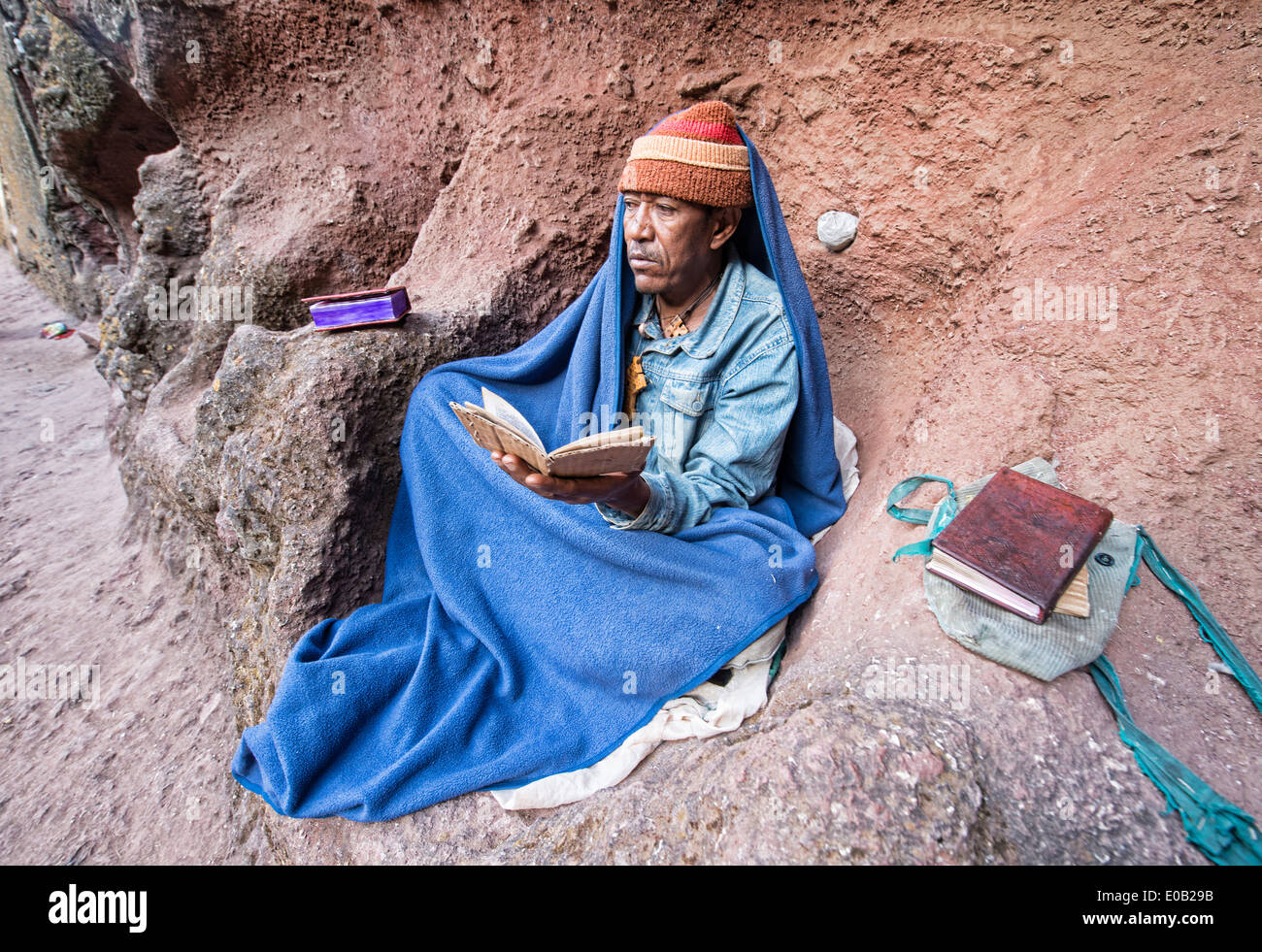 pilgrim reading his Bible at the rock hewn church of Bet Emmanuel in ...