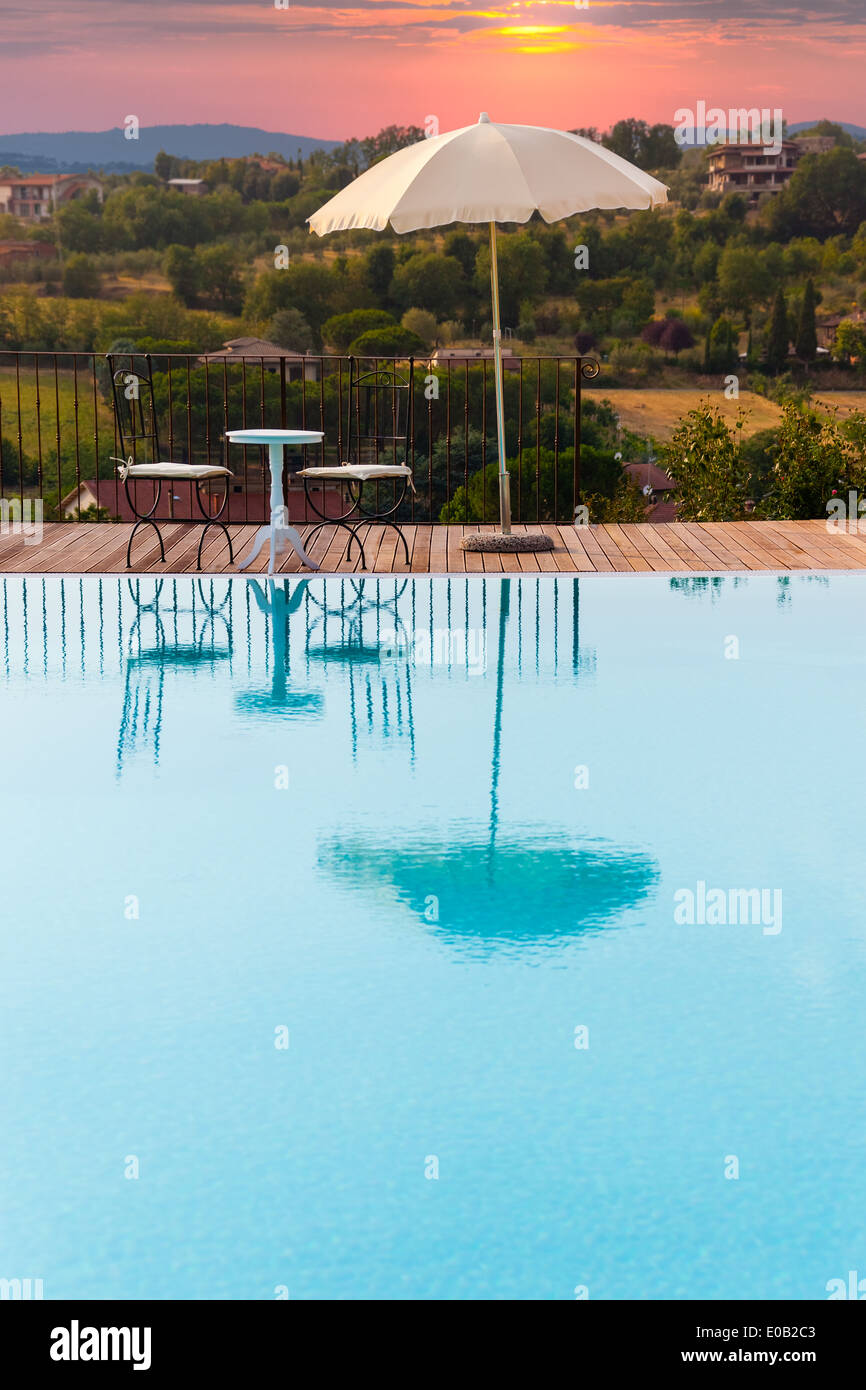a beautiful and luxurious tuscany swimming pool with parasols and ...