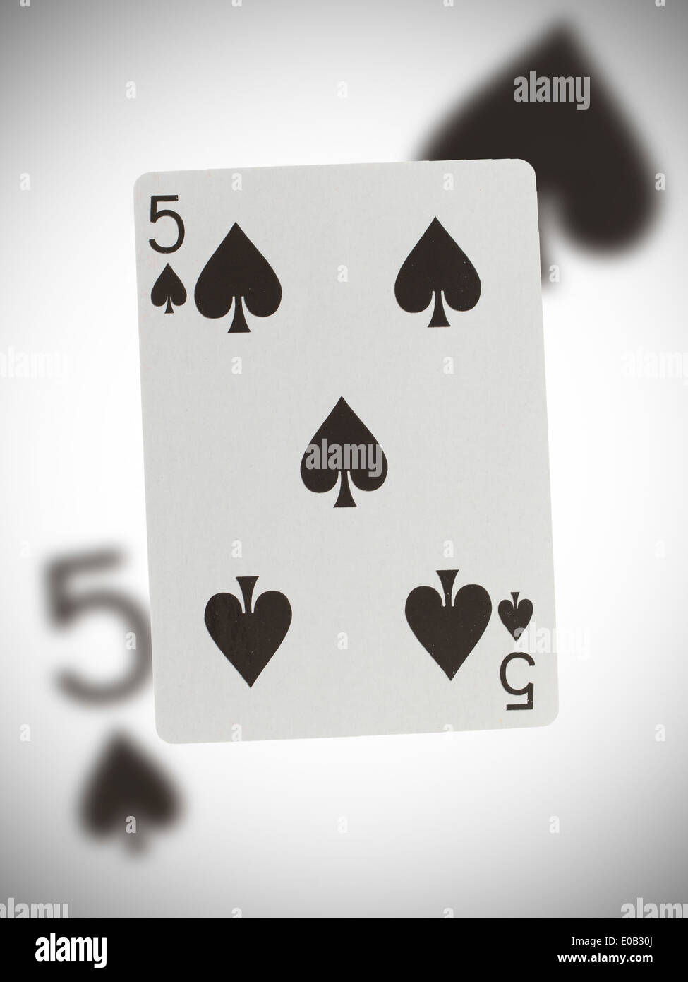 Playing card with a blurry background five of spades Stock Photo - Alamy