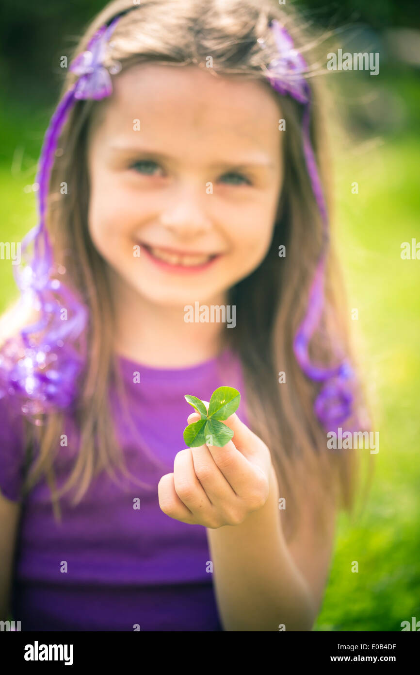 Little girl showing four leaved clover Stock Photo - Alamy