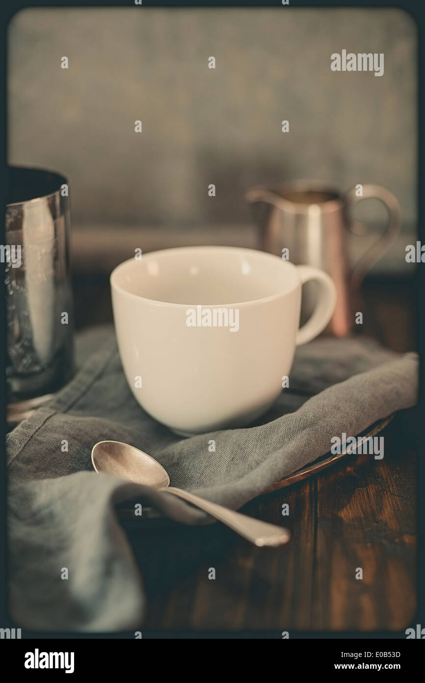 White cup on silver plate with silver tea caddy and milk jar Stock ...