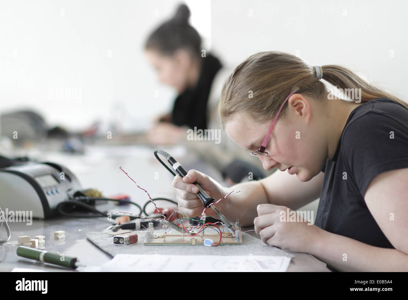 Two young women working on optical sensor in an electronic workshop ...