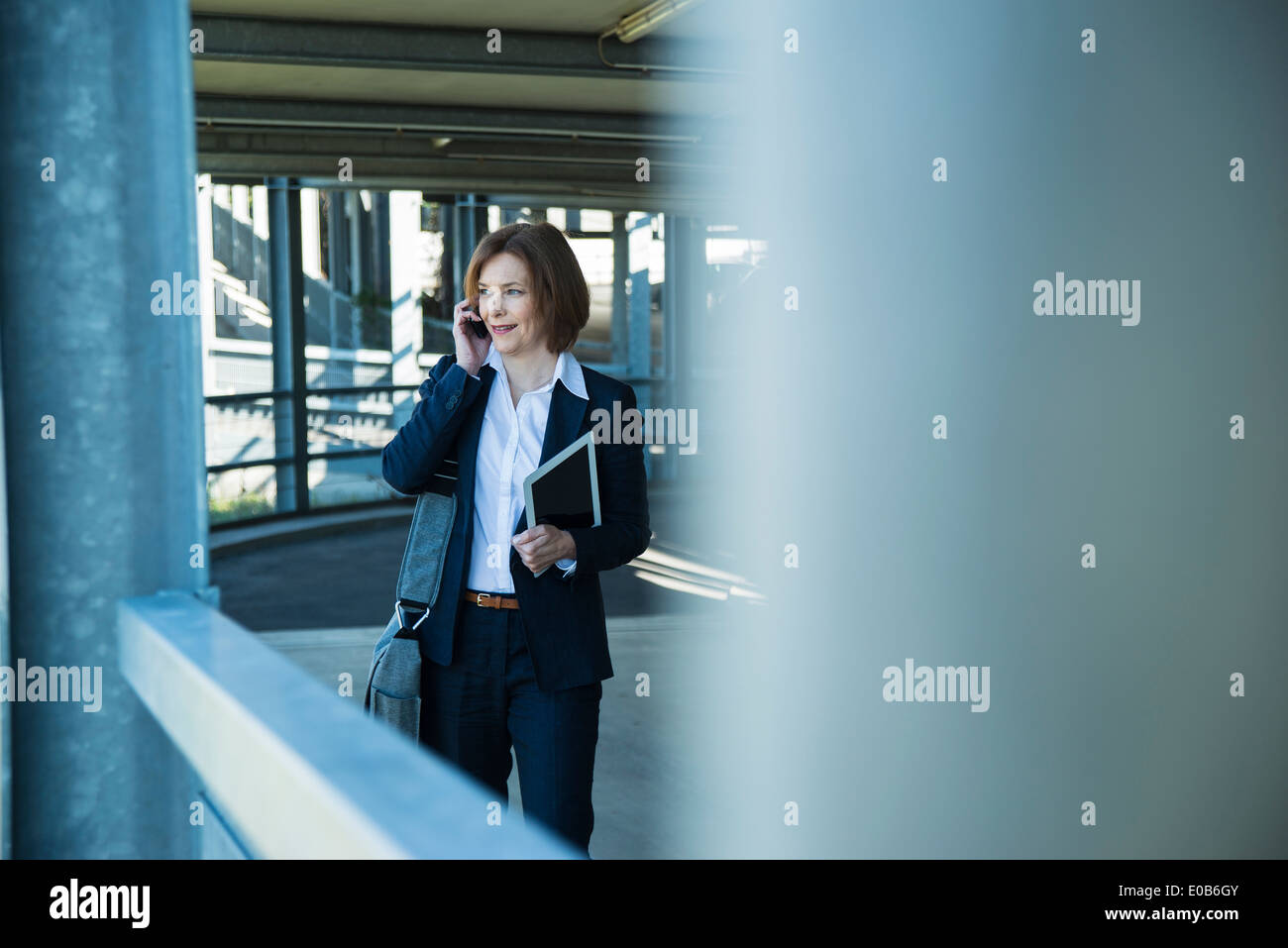 Business woman telephoning with smartphone on parking level Stock Photo ...