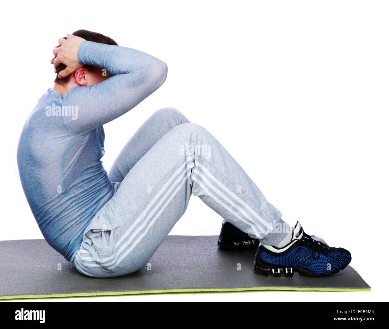 Muscular man exercising on exercise mat over white background Stock ...