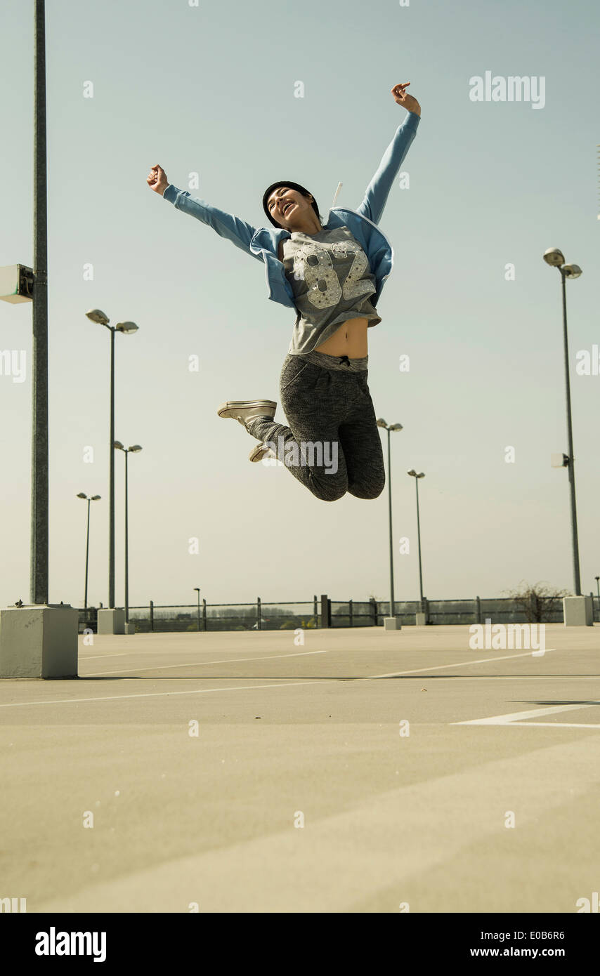Young woman jumping mid-air on parking level Stock Photo - Alamy