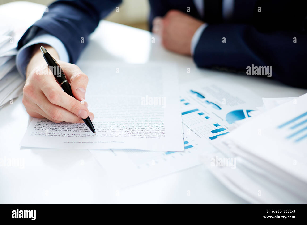 Hand of office worker with pen making notes Stock Photo - Alamy