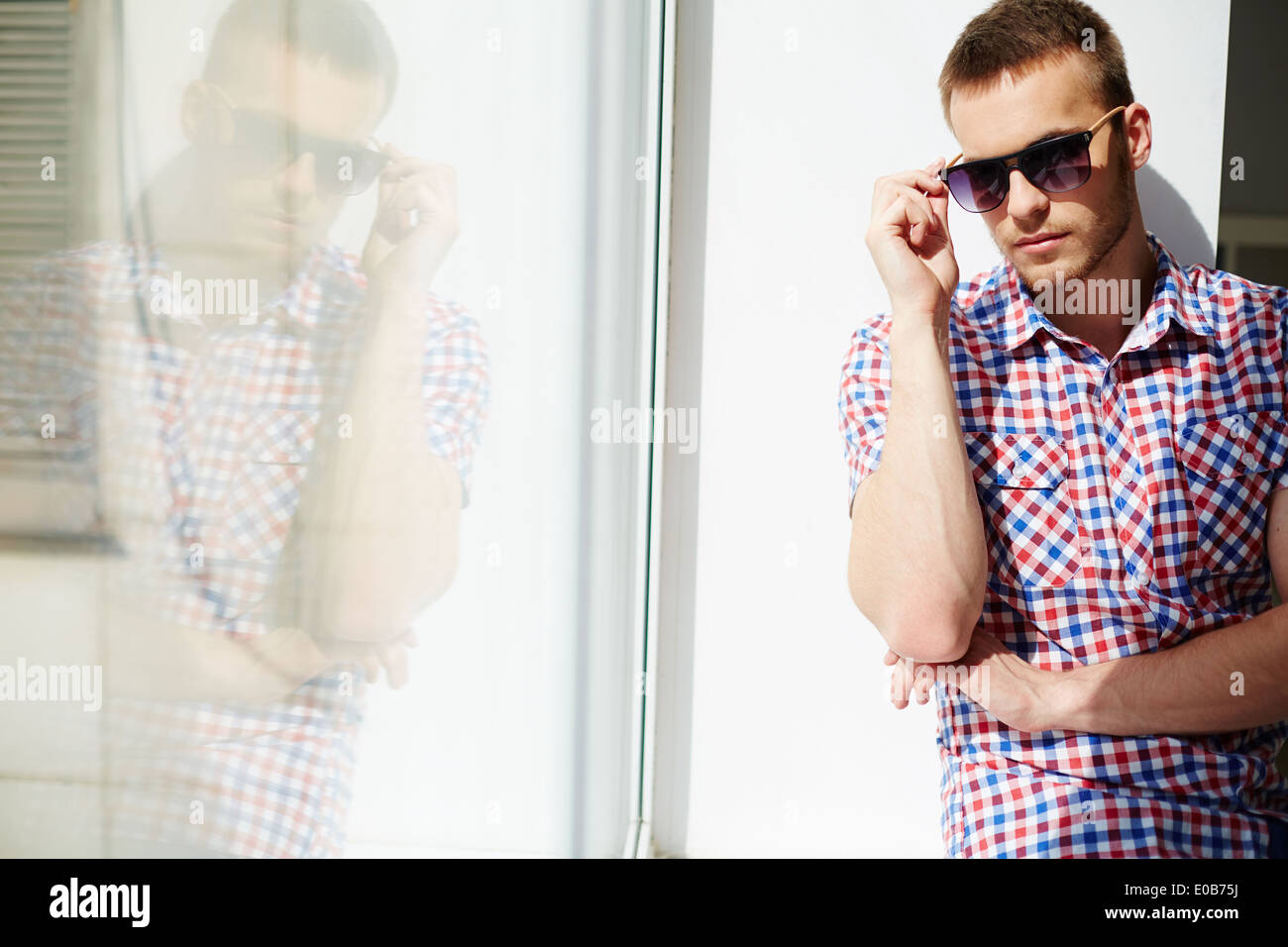 Young guy in sunglasses by the window Stock Photo - Alamy