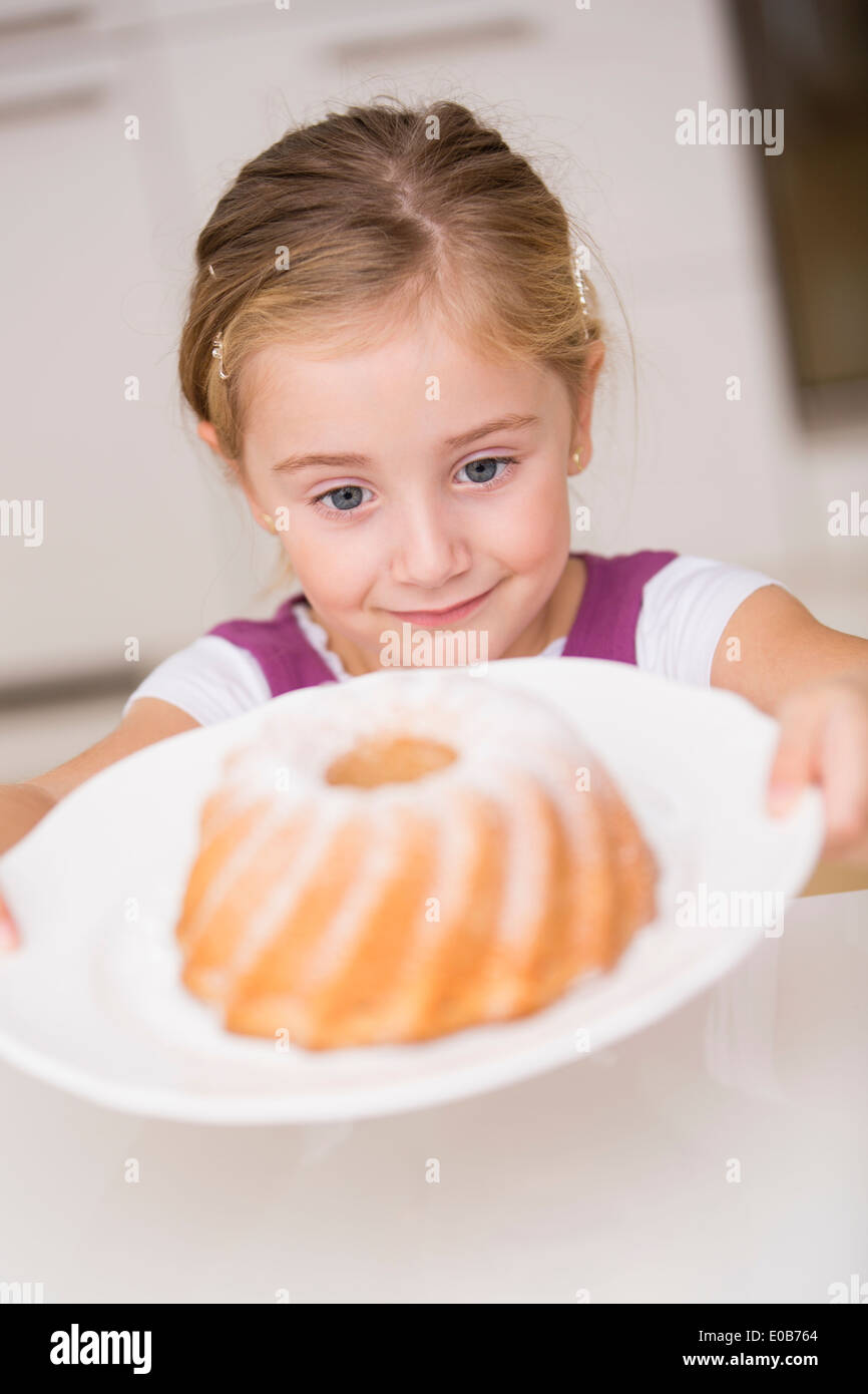 Portrait of smiling little girl taking plate with ring cake Stock Photo ...