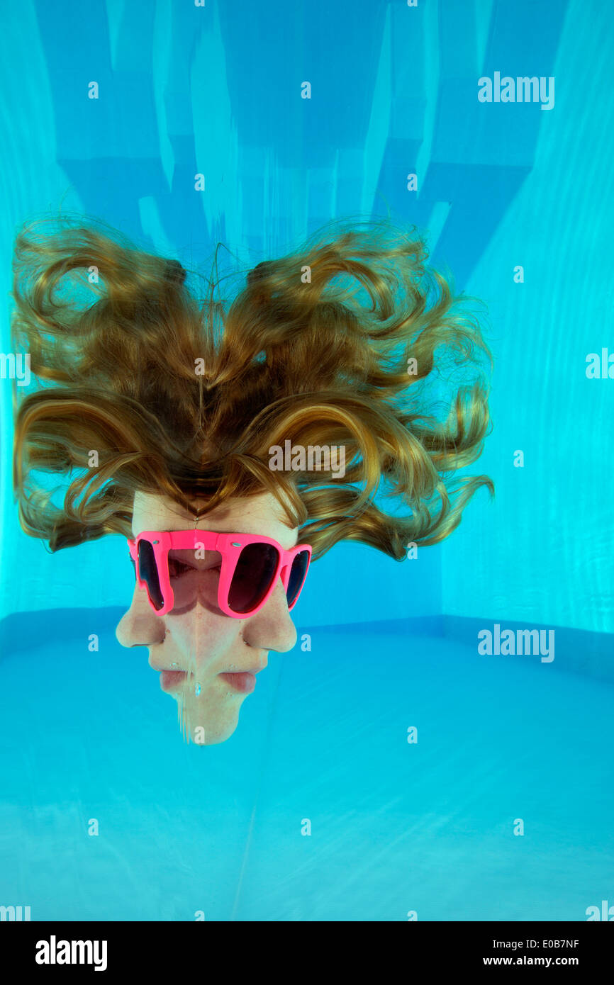 Girl with sunglasses looking through the water surface Stock Photo - Alamy