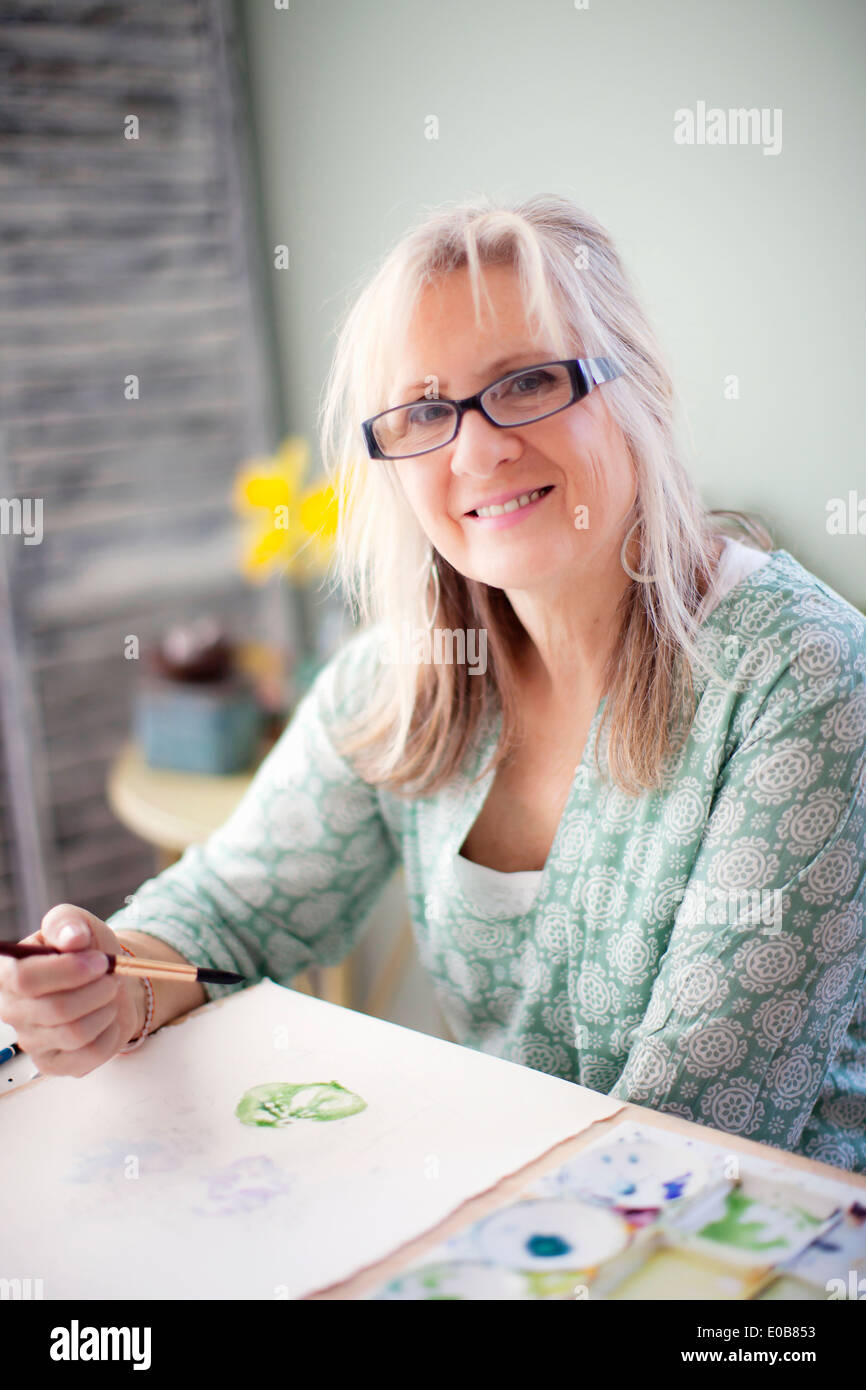 Portrait of mature female artist watercolour painting in studio Stock ...