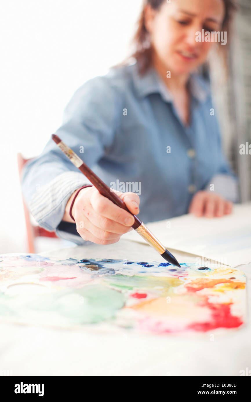 Mature woman artist painting watercolour in studio Stock Photo - Alamy