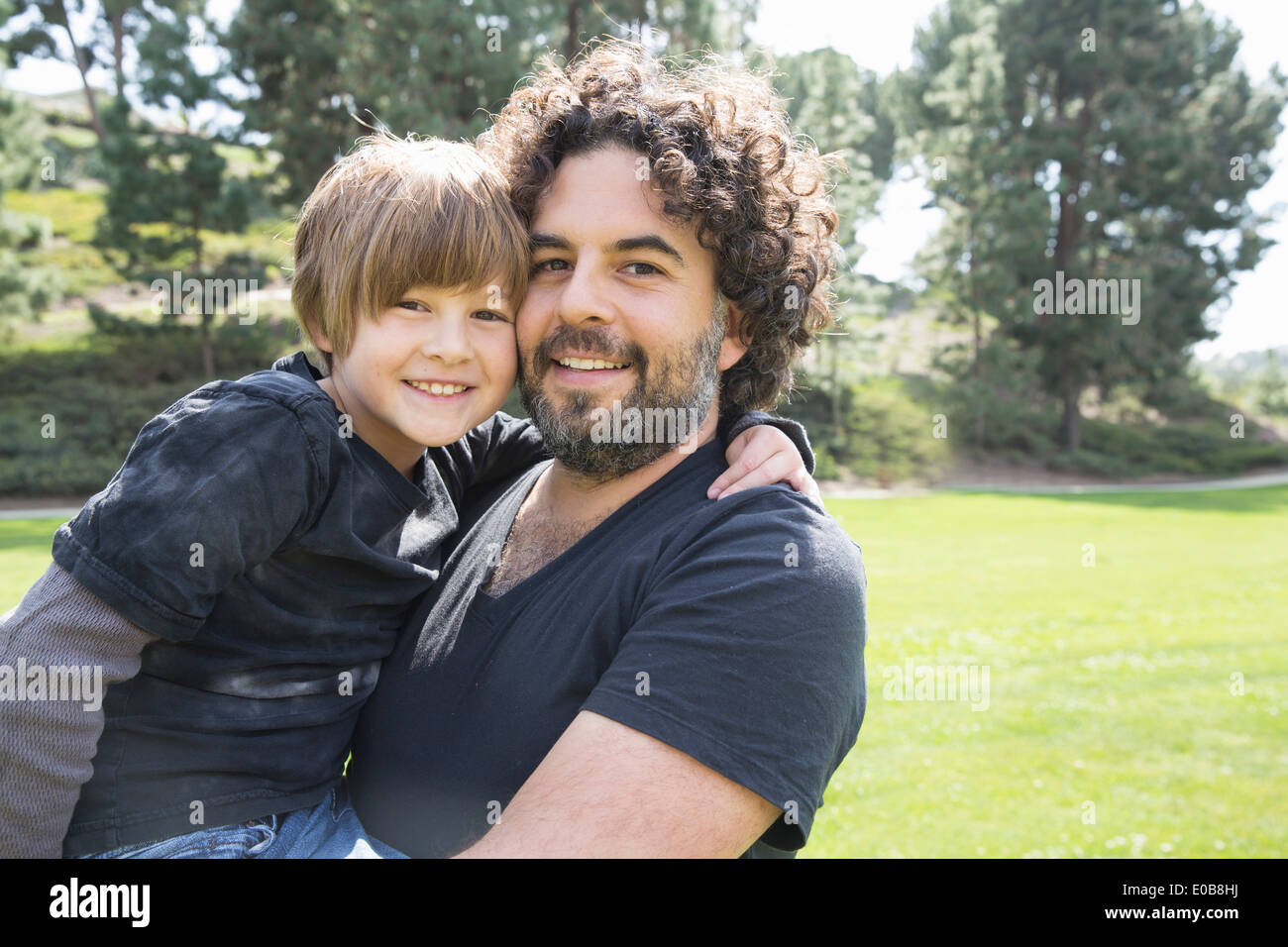 Portrait of proud father and son in park Stock Photo - Alamy
