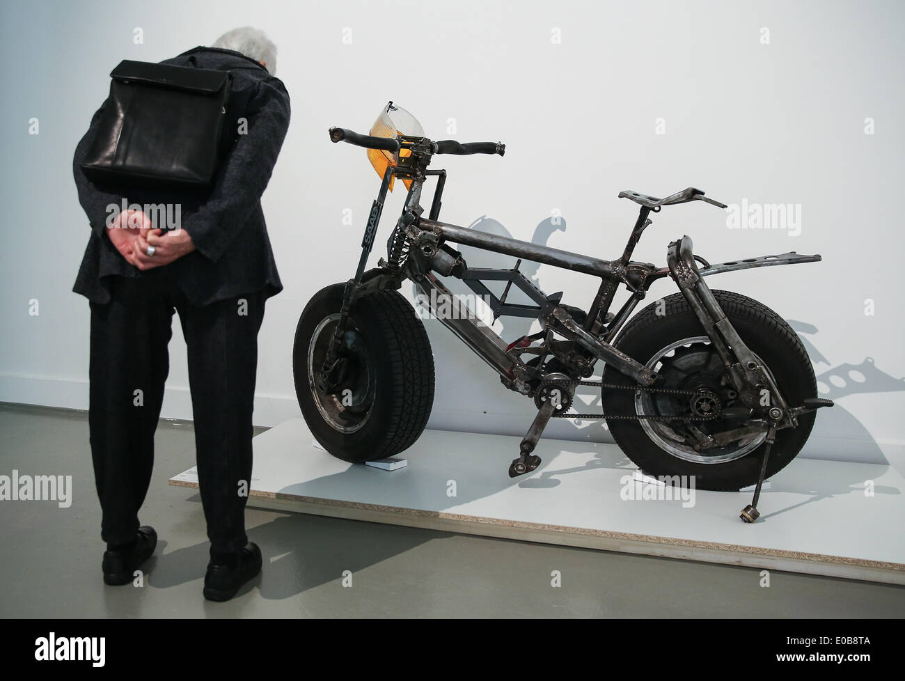 A woman looks at a bike, which has been made of parts of a Saab 900 ...