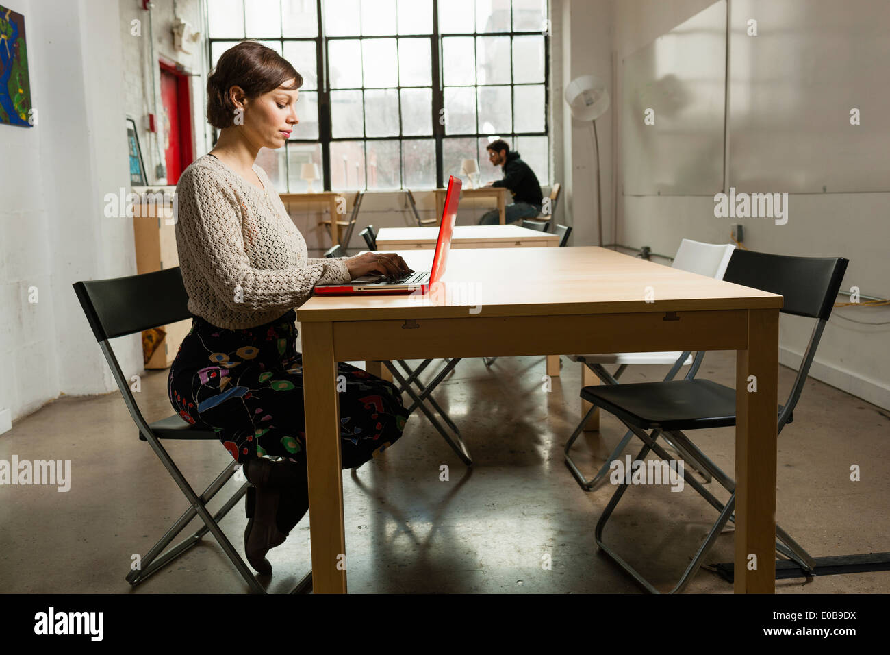Young female designer busy on laptop in design studio Stock Photo - Alamy