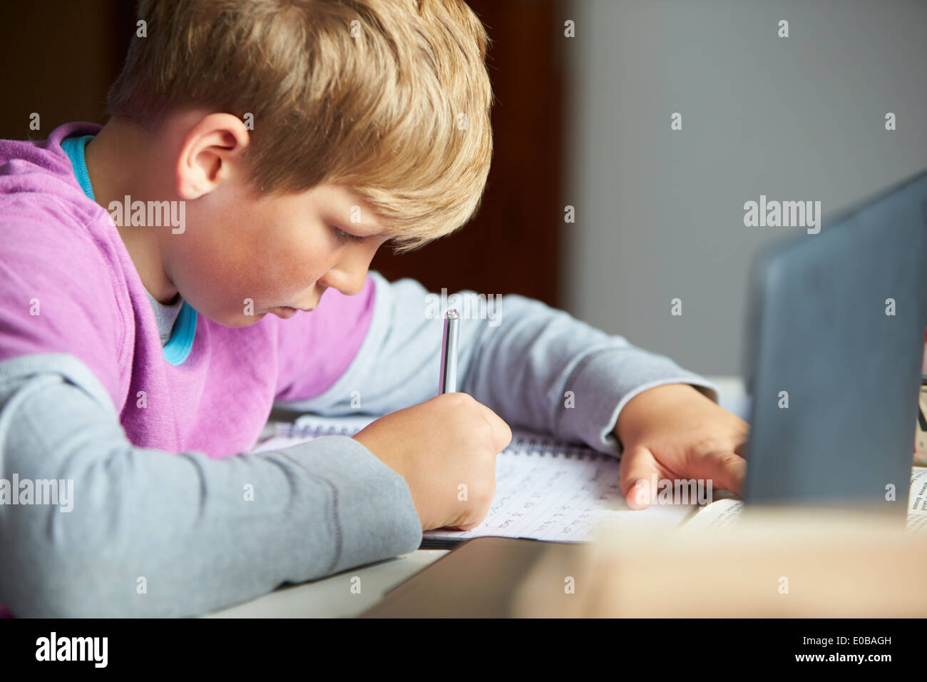 Boy Studying In Bedroom Using Laptop Stock Photo - Alamy