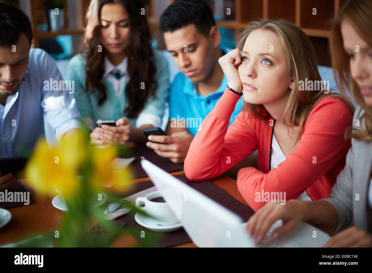 Portrait of teenage friends using modern gadgets while sitting in cafe ...
