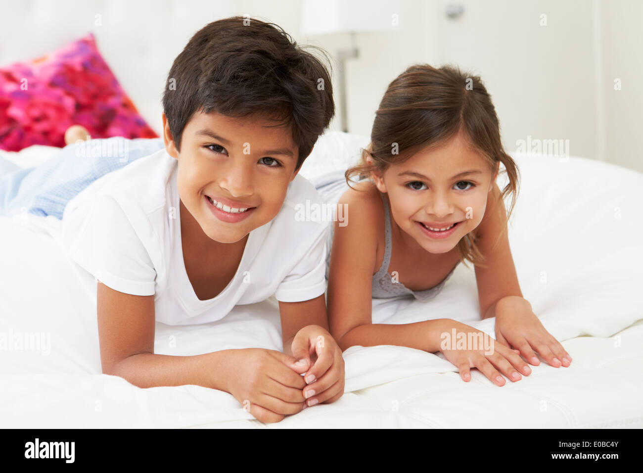 Children Lying On Bed In Pajamas Together Stock Photo - Alamy
