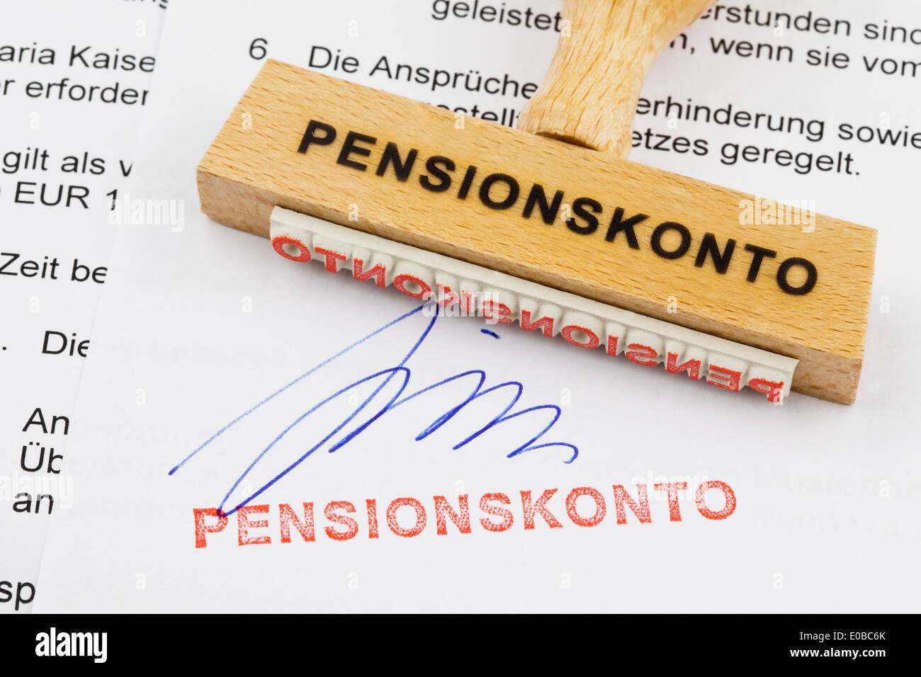 A stamp of wood lies on a document. German label: Pension discount ...