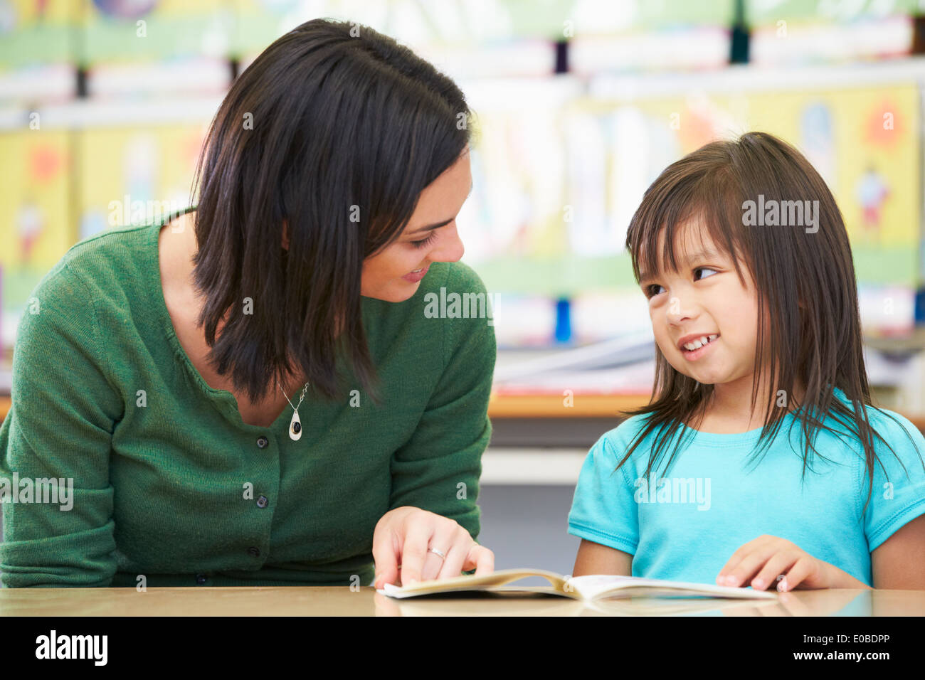 Elementary Pupil Reading With Teacher In Classroom Stock Photo - Alamy