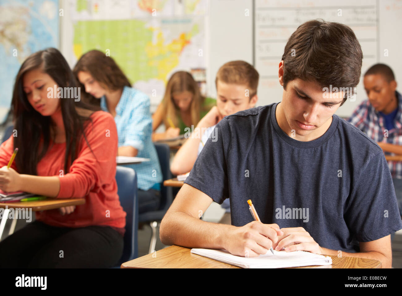Male Pupil Studying At Desk In Classroom Stock Photo - Alamy