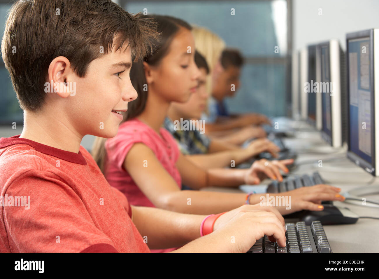 Elementary Students Working At Computers In Classroom Stock Photo - Alamy