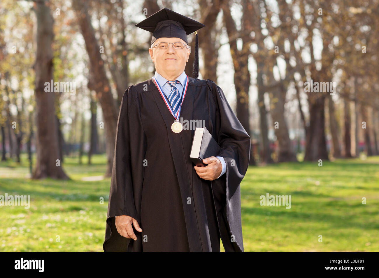 Proud university dean posing in a park with a book in his hand Stock ...