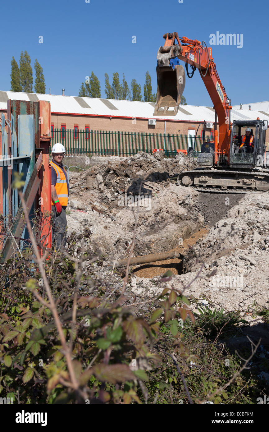 Earth moving digger operating on construction site Stock Photo - Alamy