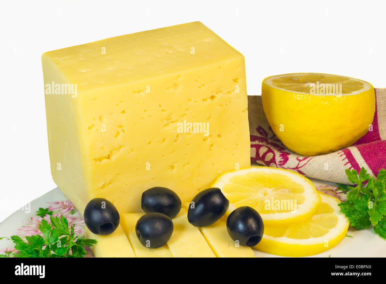Piece of the yellow porous cheese, the cut slices of cheese, lemon and ...