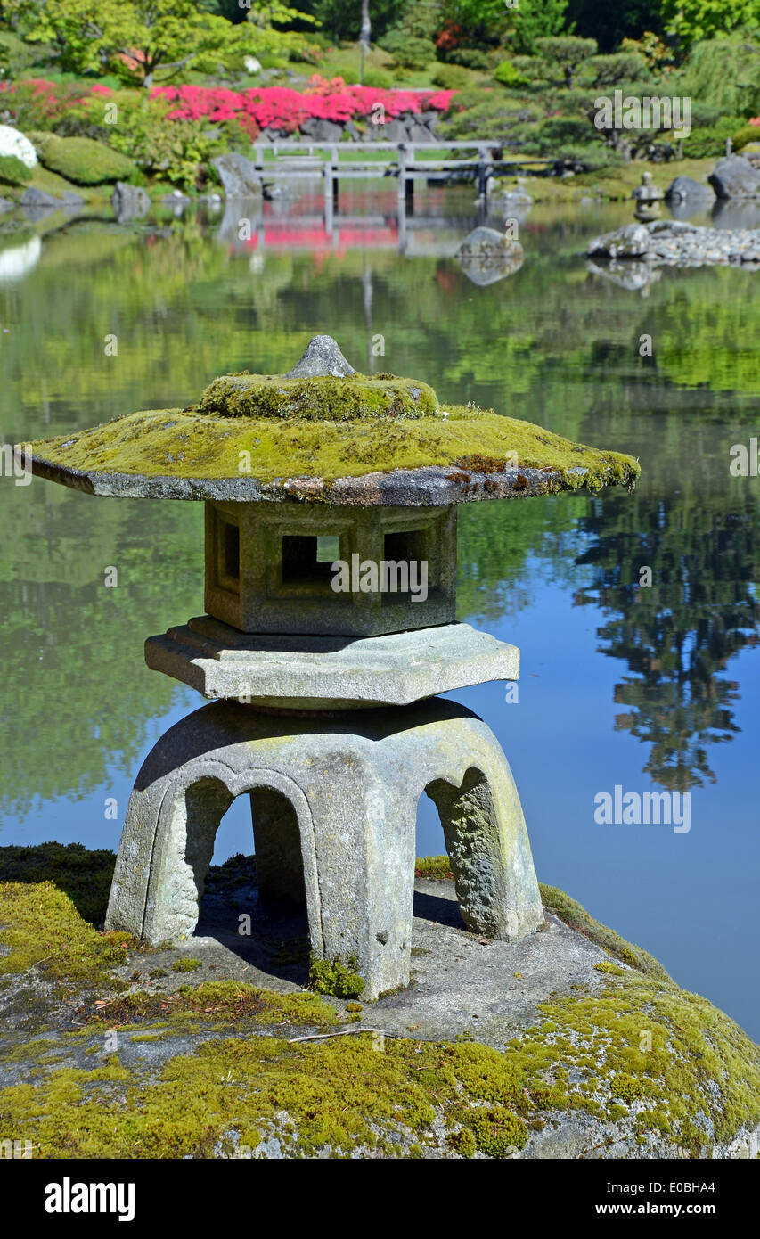 Rock lantern on rock in reflective pond in japanese botanical garden ...