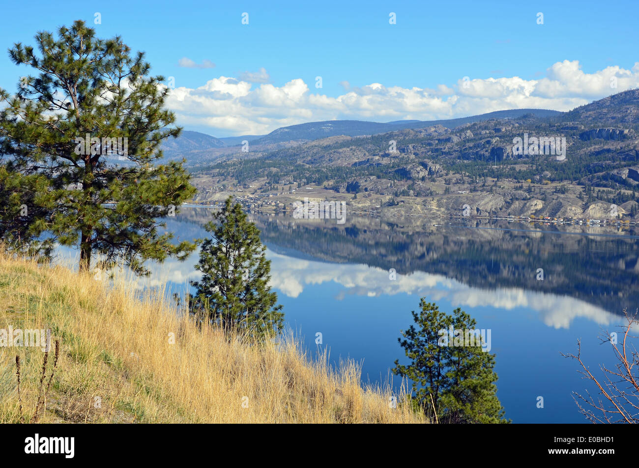 View of reflective lake with mountains and clouds Stock Photo - Alamy