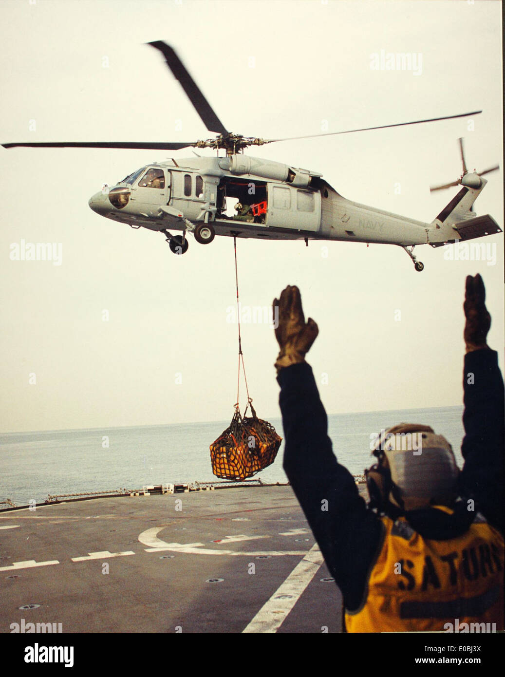 The CH-60, a military helicopter, is seen on the flight deck with its ...