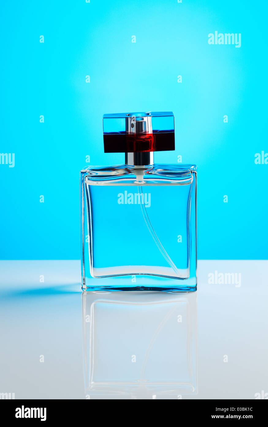 Perfume on blue background with reflection Stock Photo - Alamy