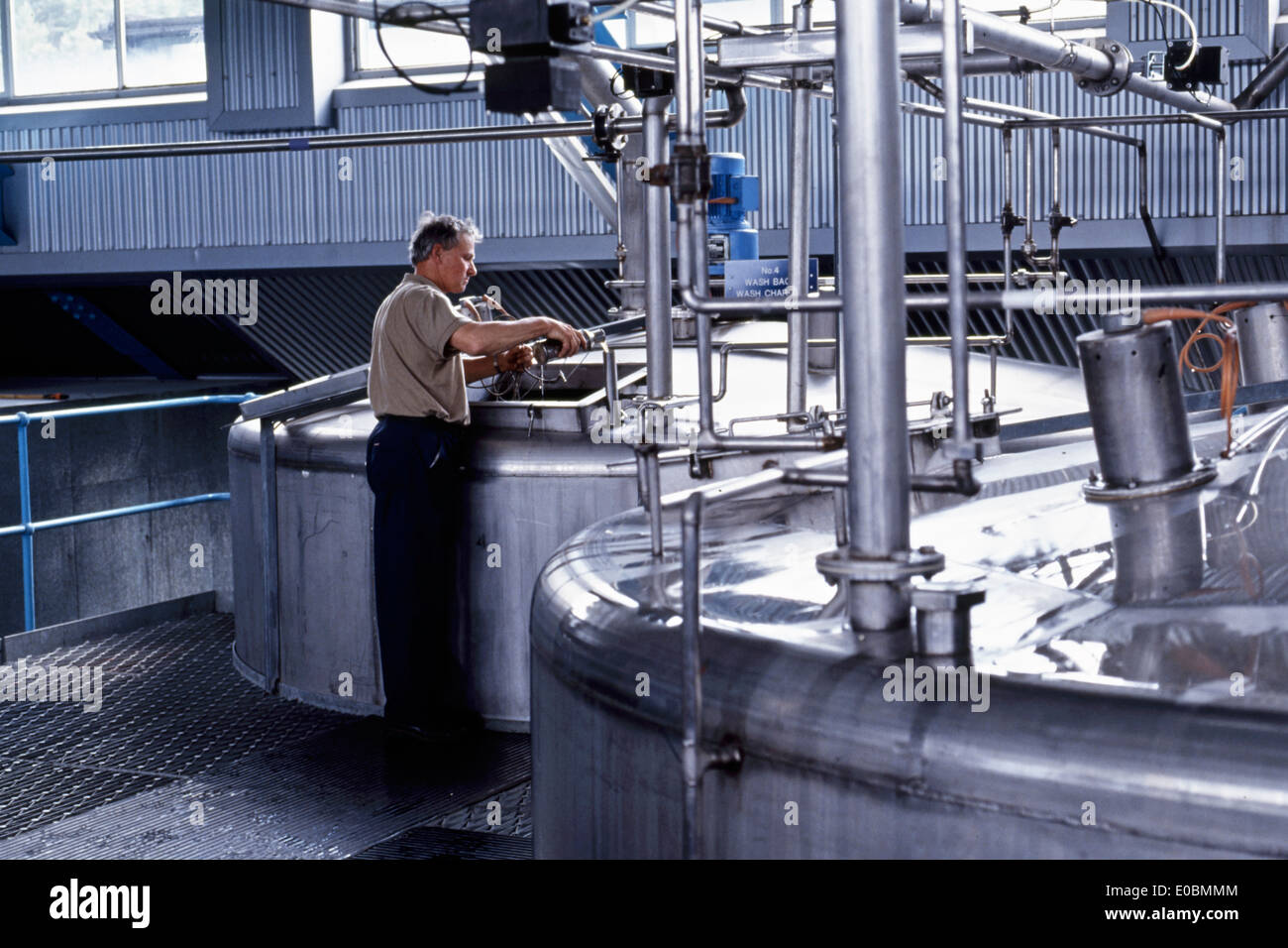 Scottish distillery worker at steel mash tun Stock Photo - Alamy