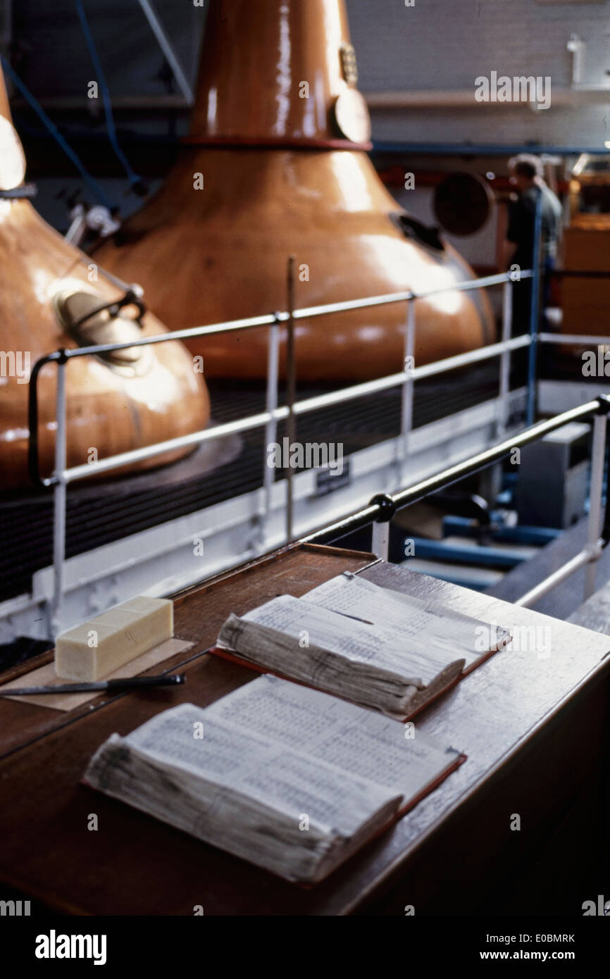 Scottish distillery log books in front of copper stills with worker ...