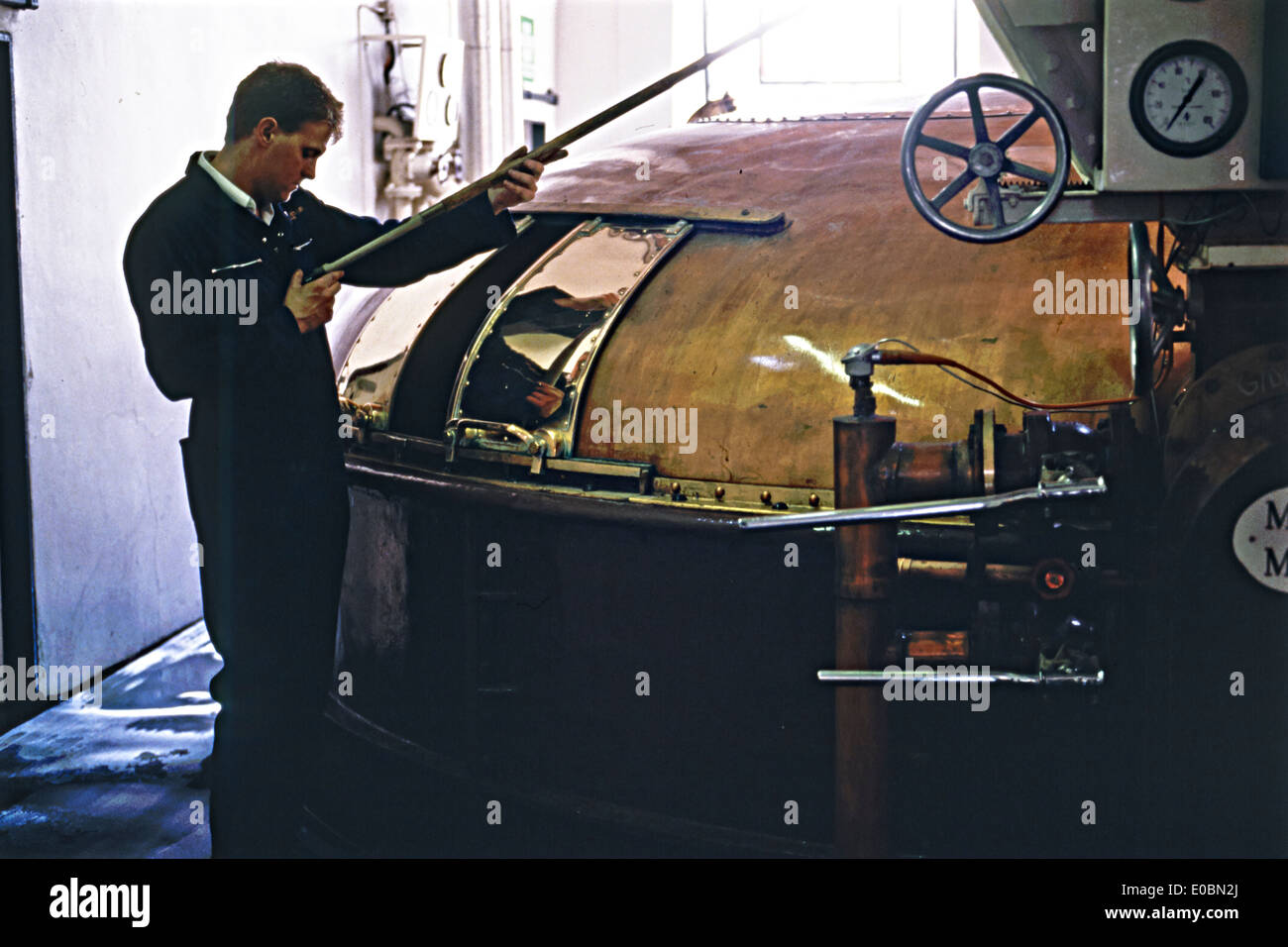 Scottish distillery worker tests brew in mash tun Stock Photo - Alamy
