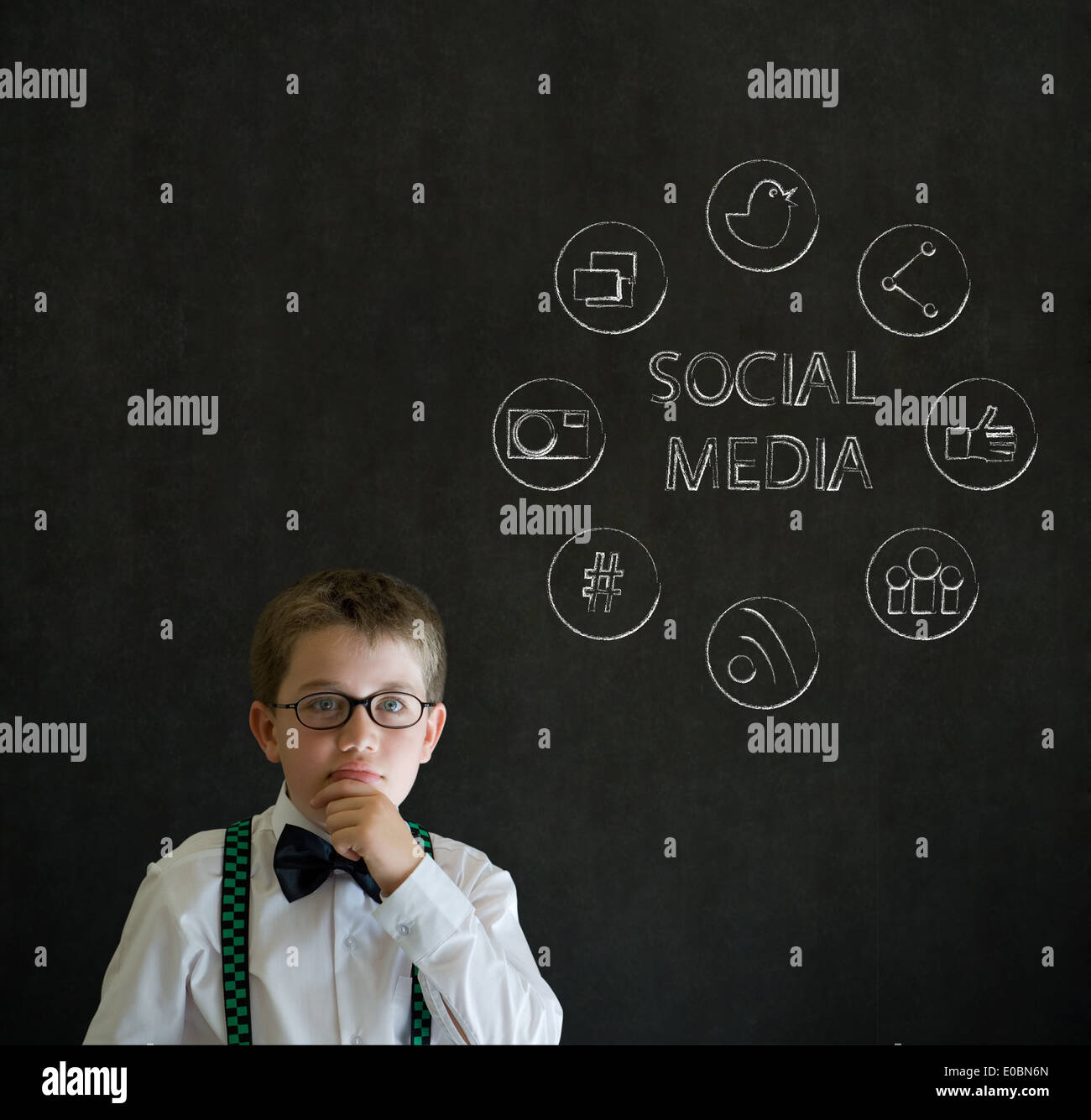 Thinking boy dressed up as business man with social media icons on ...