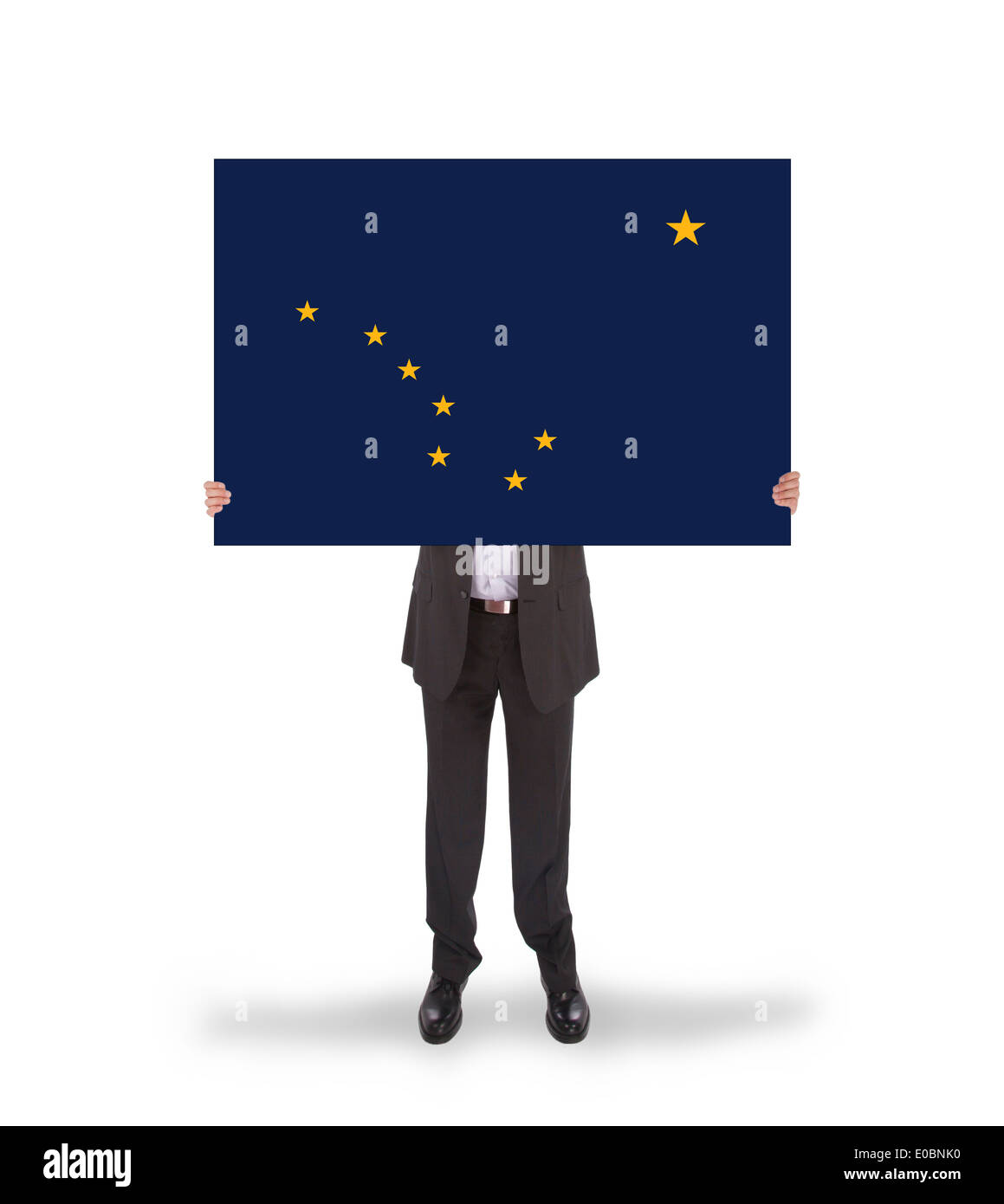 Smiling businessman holding a big card flag of Alaska isolated on white ...