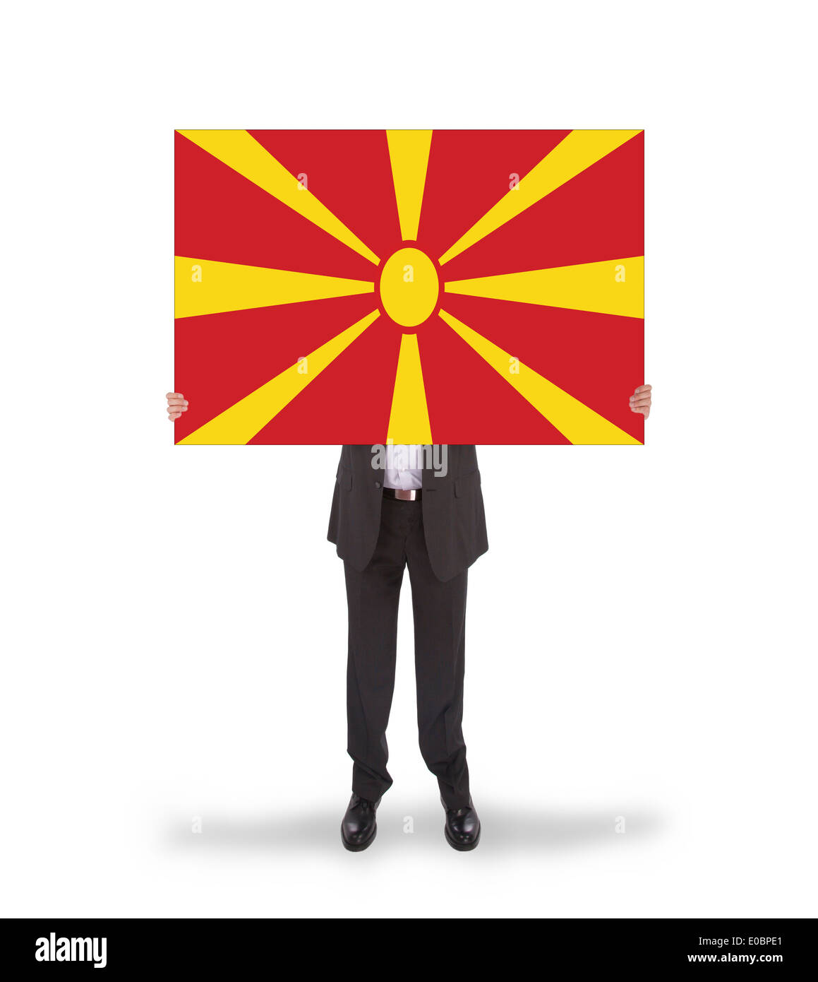 Businessman holding a big card flag of Macedonia isolated on white ...