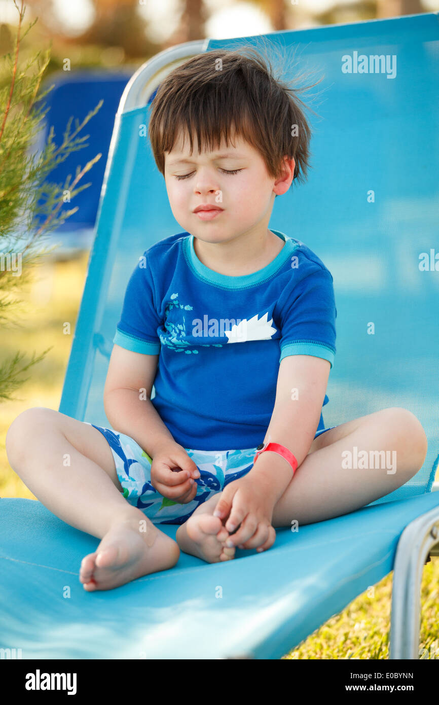 Cute toddler boy sitting on a sunbed Stock Photo - Alamy