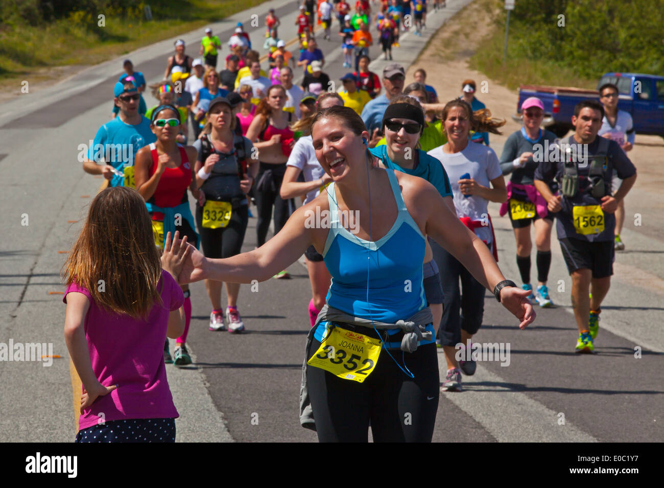 A young girl gives a high five to runners near the end of the 2014 Big ...