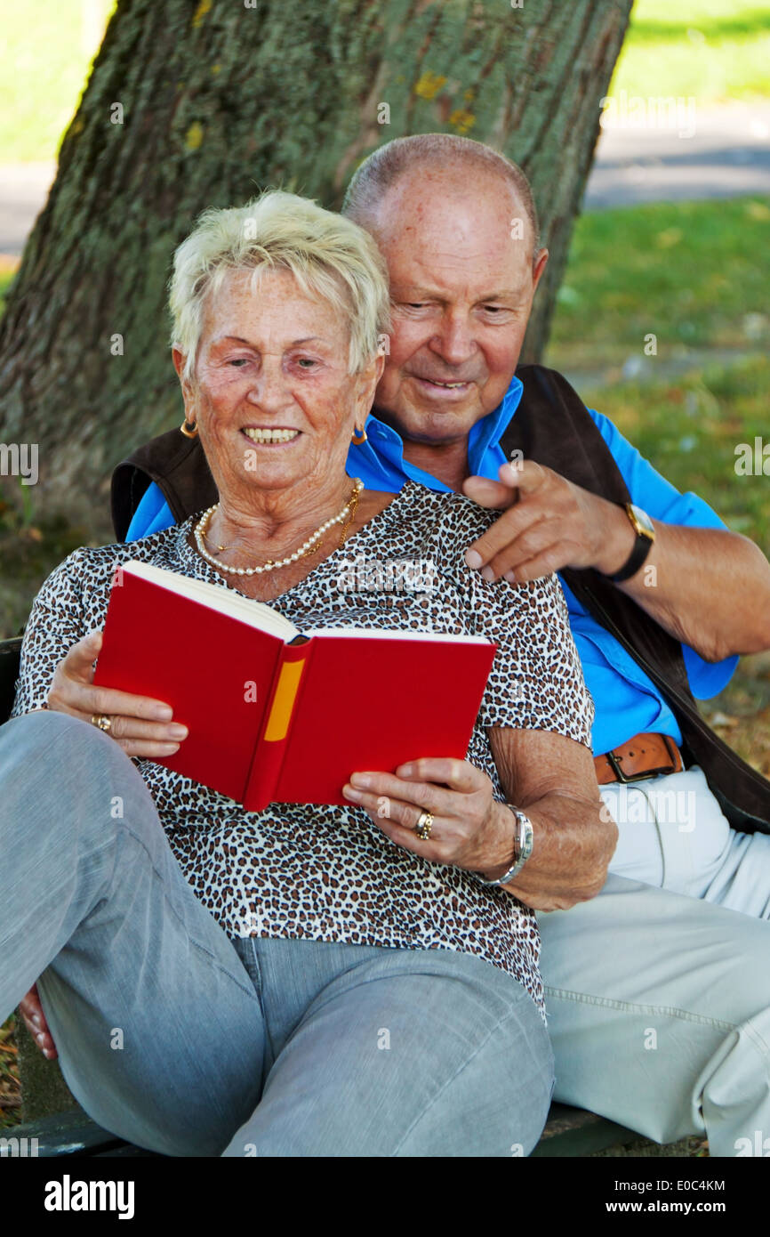 older senior citizens married couple are in love. read a book, aelteres ...